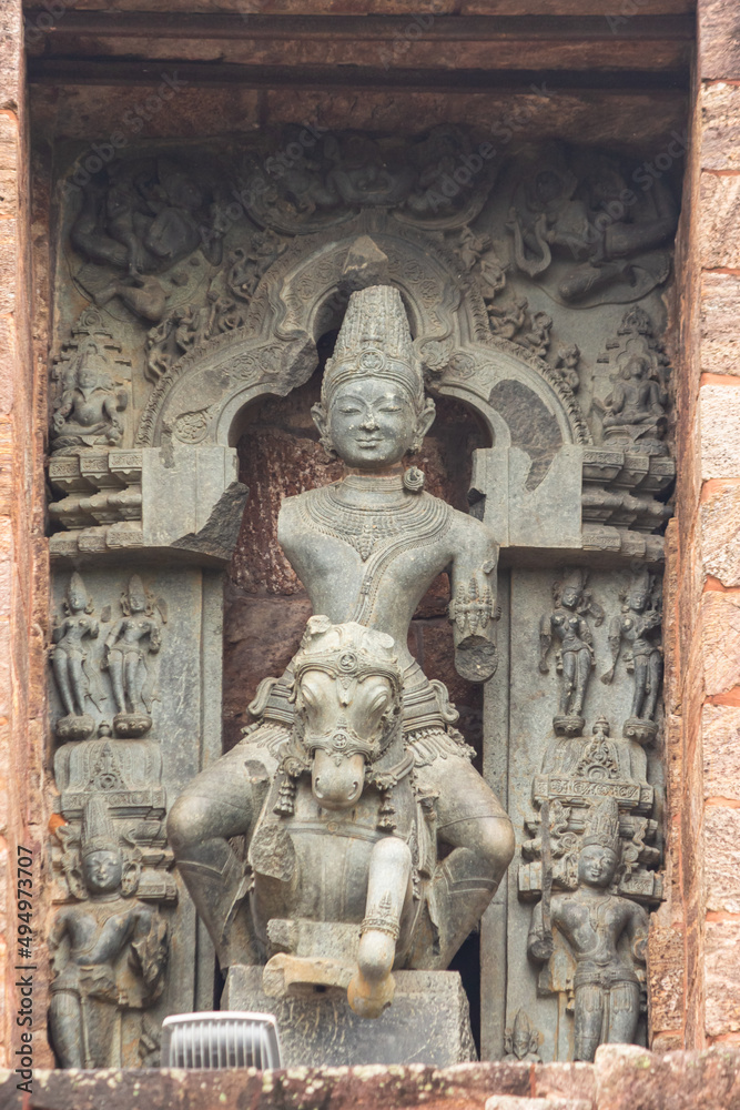 Statue of Vedic Sun god Surya or Arka in mellow mood carved on the wall ...