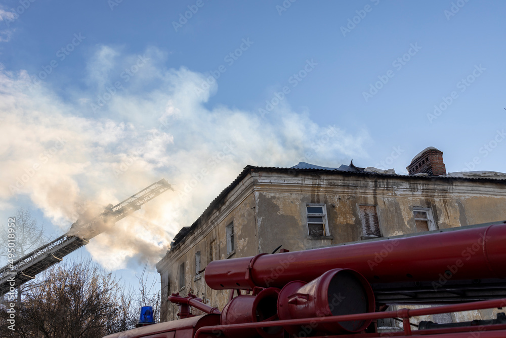 Firefighter works on boom of fire engine. Fireman on sky background ...