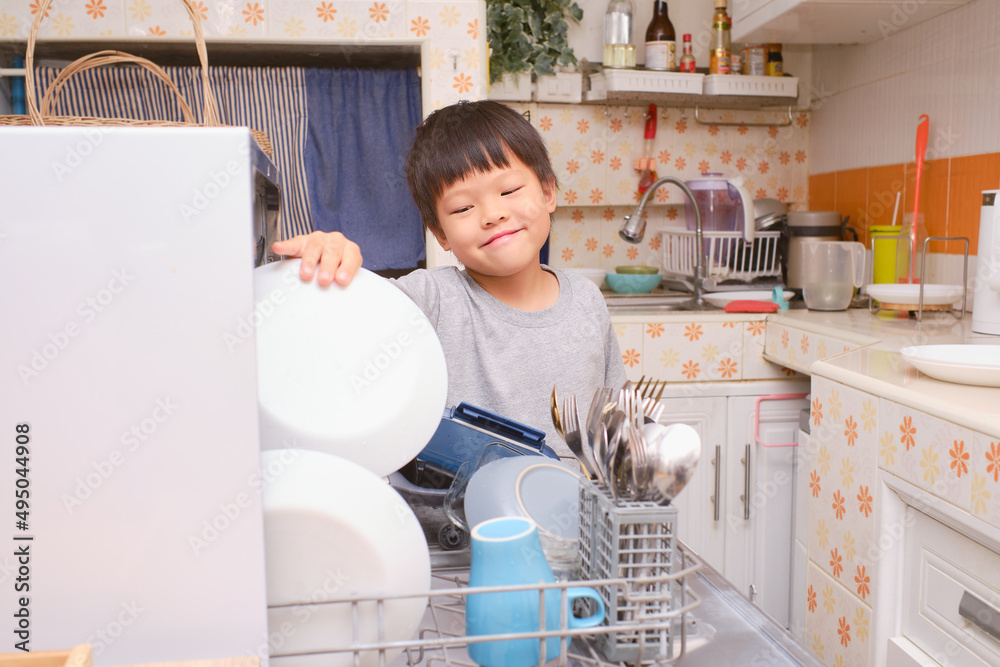 Cute Asian boy child having fun doing the dishes, washing dishes ...