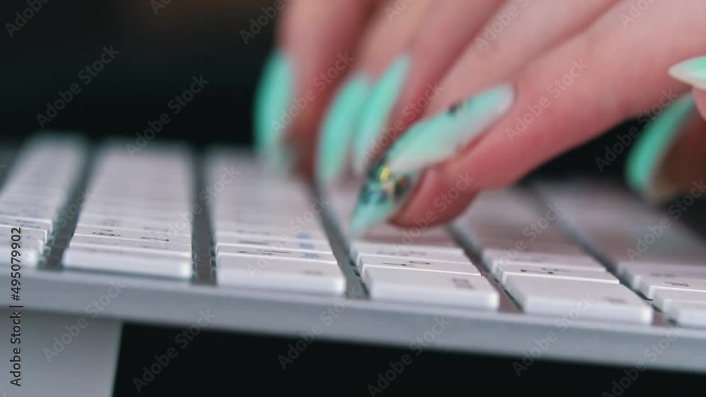 Business woman's fingers are typing on the keyboard of a white laptop ...
