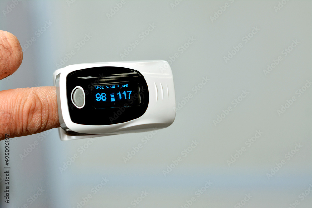 fingertip pulse oximeter equipment connected to the index finger of a ...