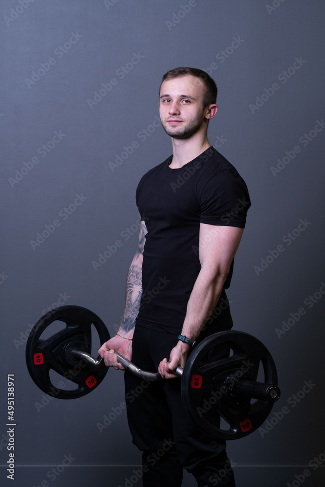 Guy with a barbell in a black fitness T-shirt muscular bodybuilder ...