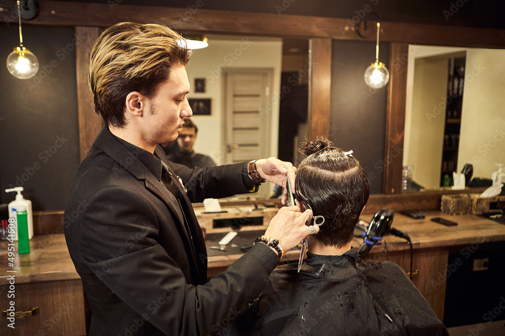 Salon. Man in a barber chair. The hairdresser serves the client in the ...