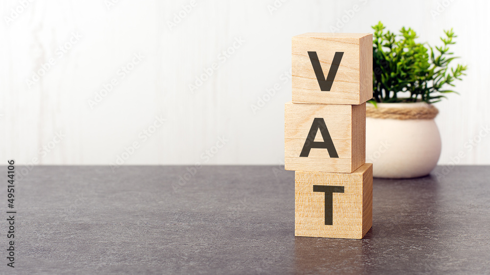 letters of the alphabet of VAT on wooden cubes, green plant, white ...