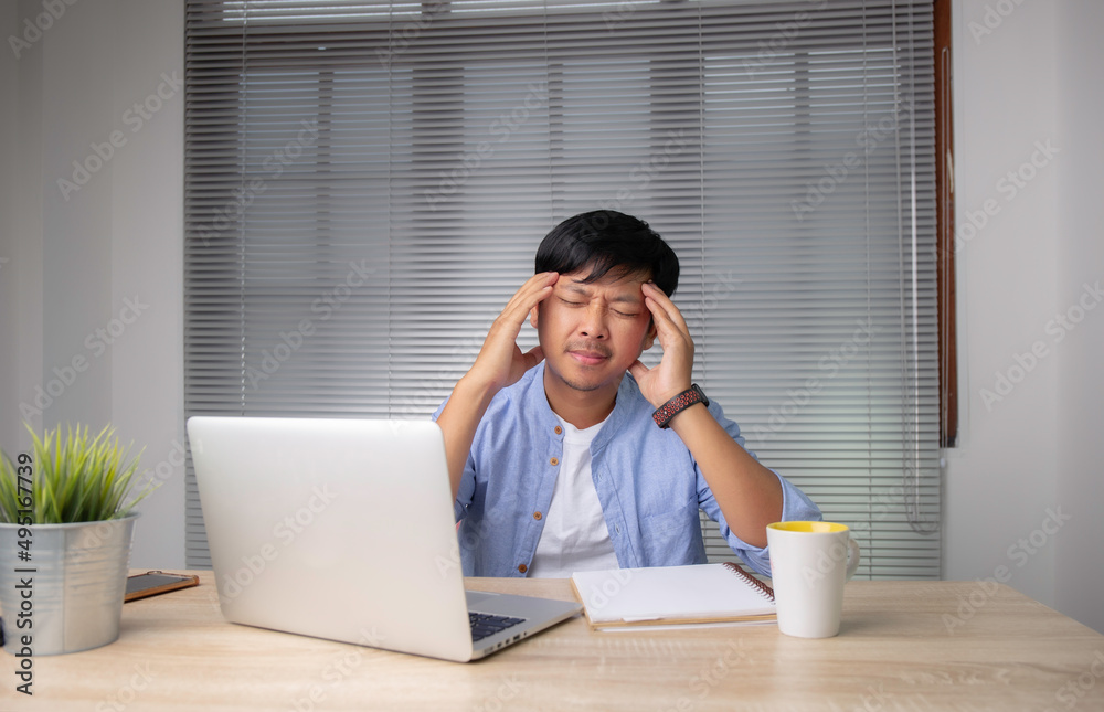 businessman is tired from working on his desk , feeling eyestrain ...