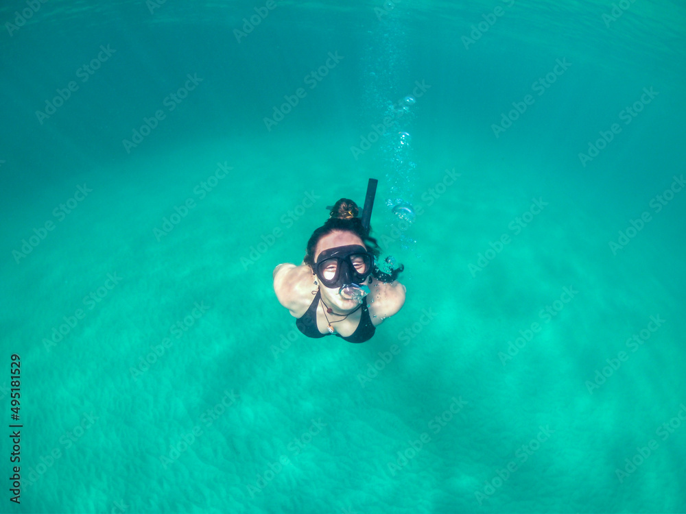 Foto de Girl diving into the ocean. Snorkel mask, turquoise water and ...