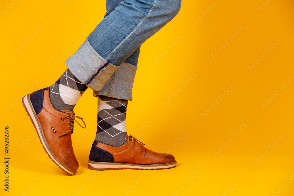 Beautiful shoes on the feet. Yellow background. Stock Photo | Adobe Stock
