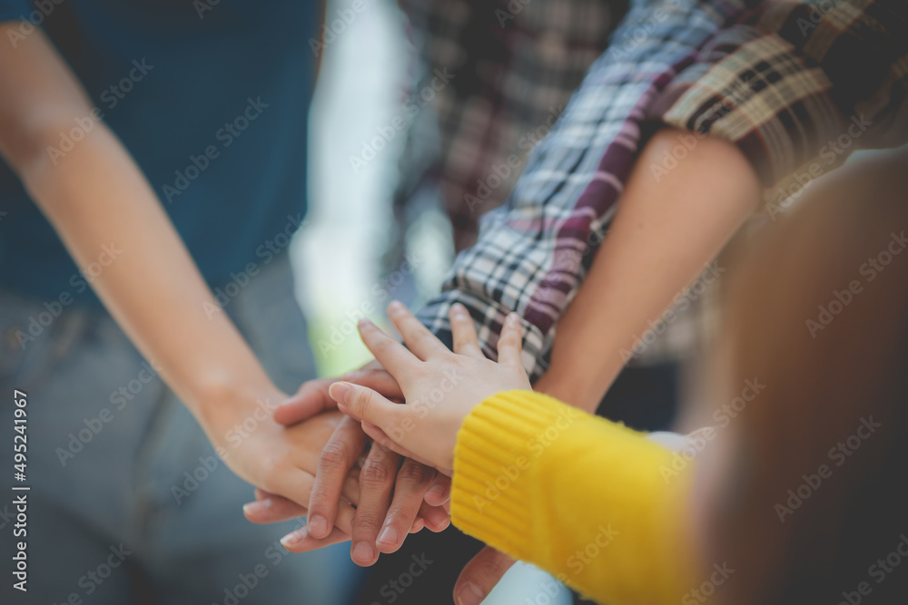 Group of business people putting their hands working together on wooden background in office ...