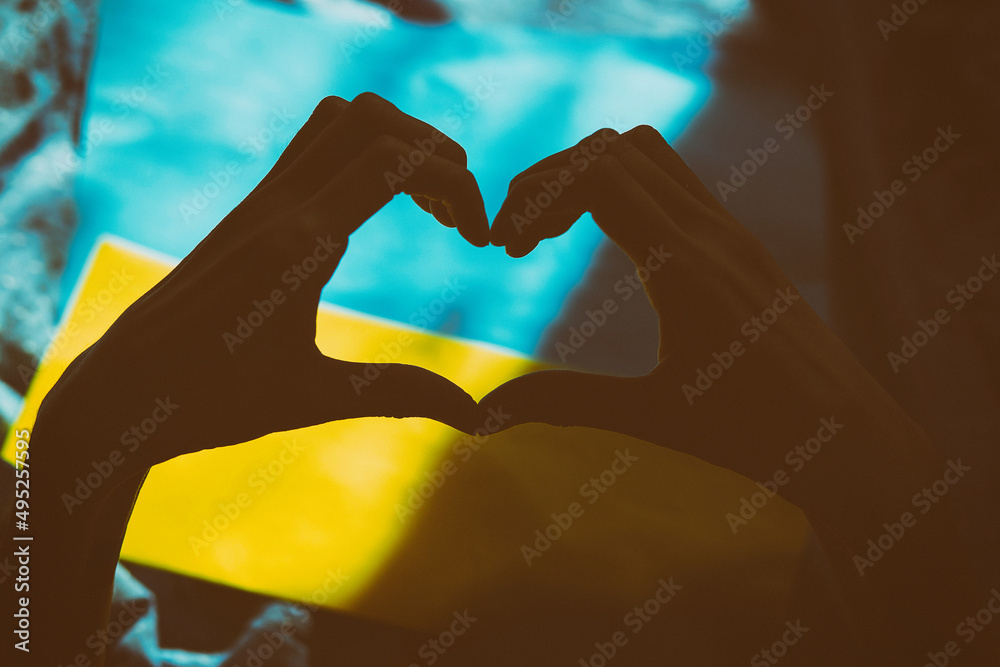 Heart shaped hands on Ukrainian flag with shadows. Vintage film ...