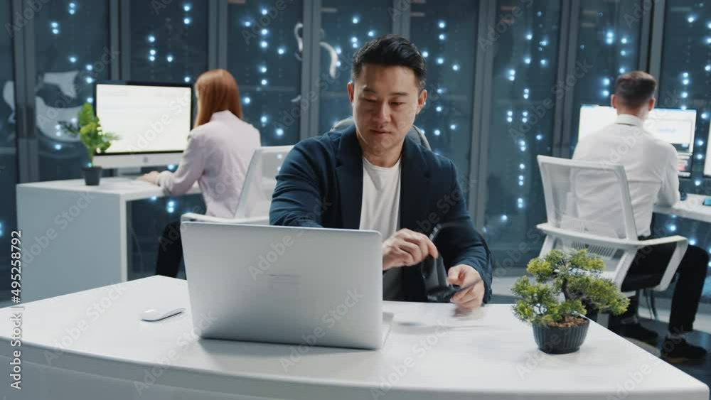 Chinese handsome executive wearing headset microphone and using ...