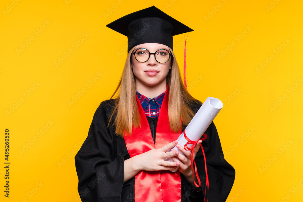 Girl graduate in graduation hat and eyewear with diploma on yellow ...