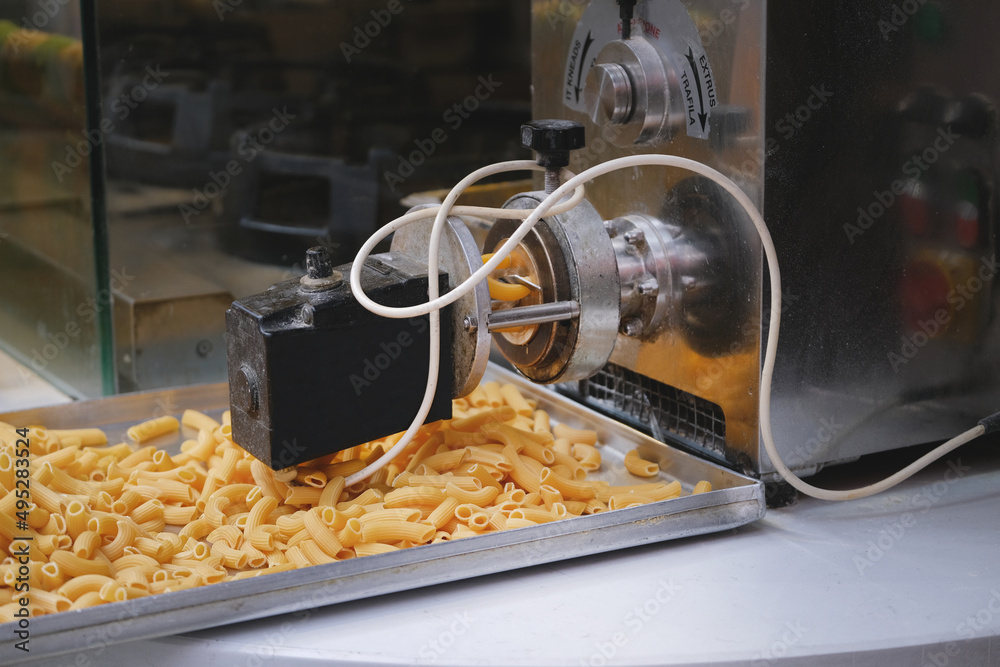 Old pasta machine stands in the window of a cafe on the street, making ...
