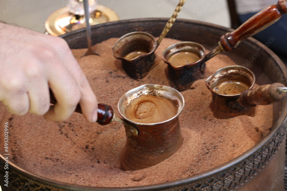 Turkish coffee cooked in hot sand in copper coffee pots prepared for ...