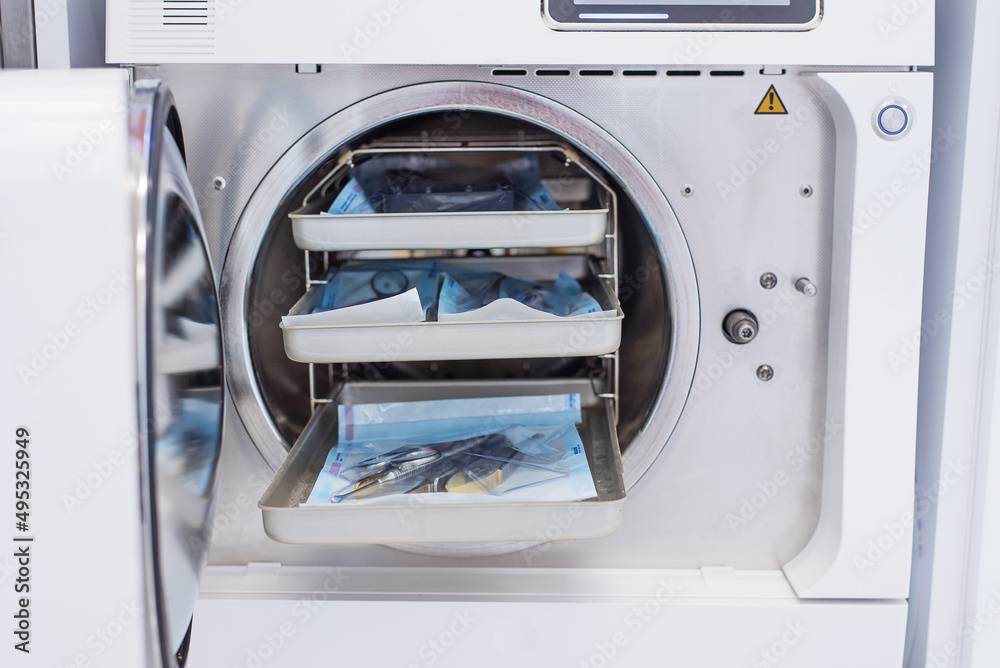 Modern laboratory autoclave with packaged dental instruments in ...