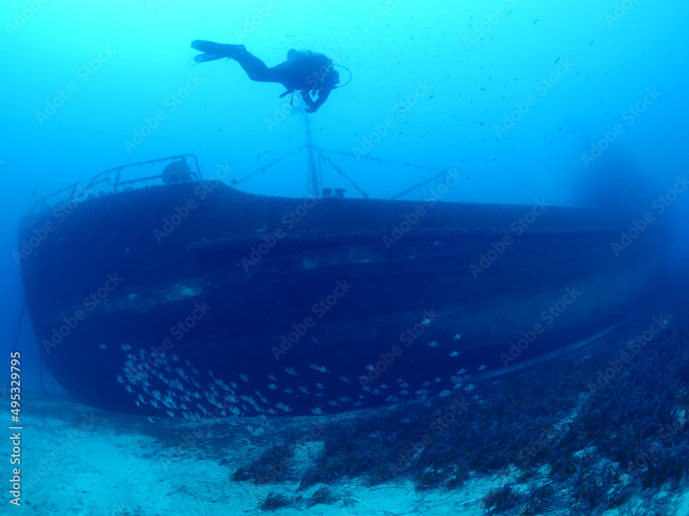 scuba divers exploring and discovering the ship wreck underwater deep ...