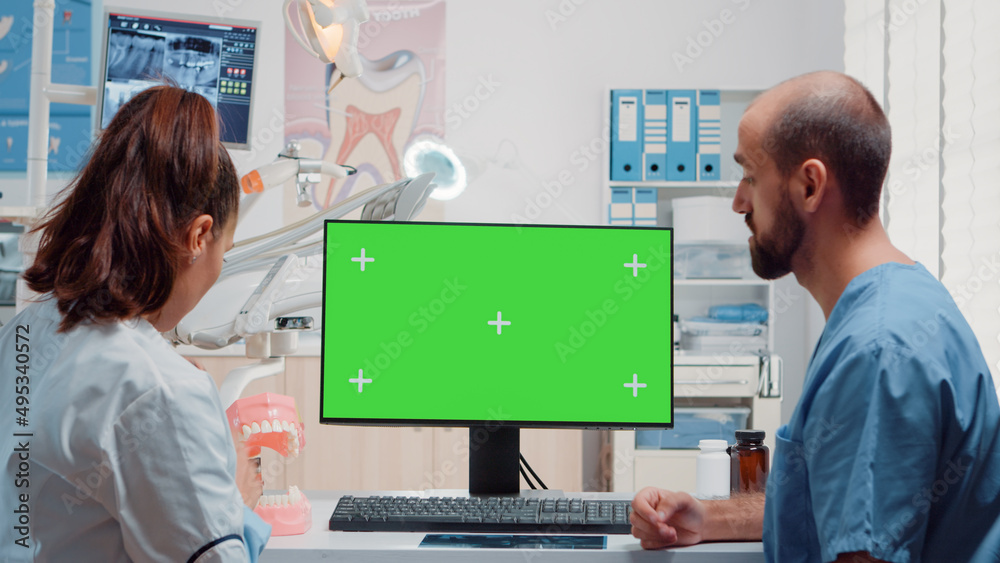 Dentist and man nurse analyzing green screen on computer while looking ...