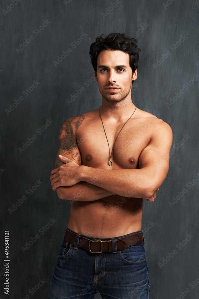 Confident and buff. A shirtless young man standing with his arms folded ...