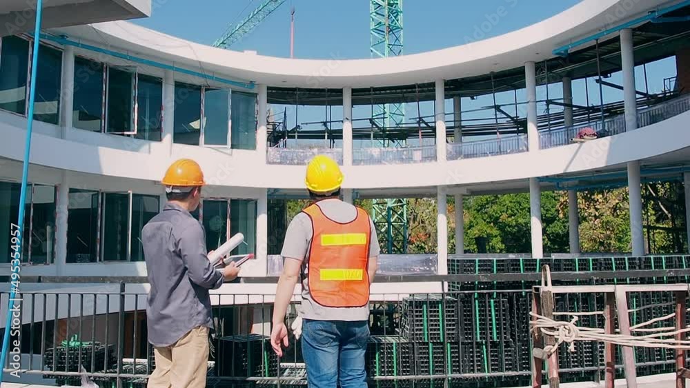 Two young structural engineer and architect dressed in orange work ...