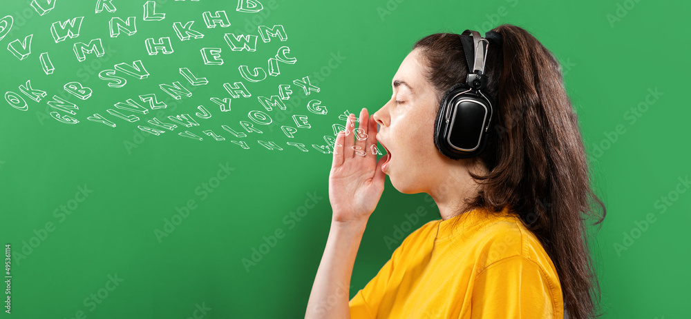 Online language learning. Portrait of a young woman wearing headphones ...