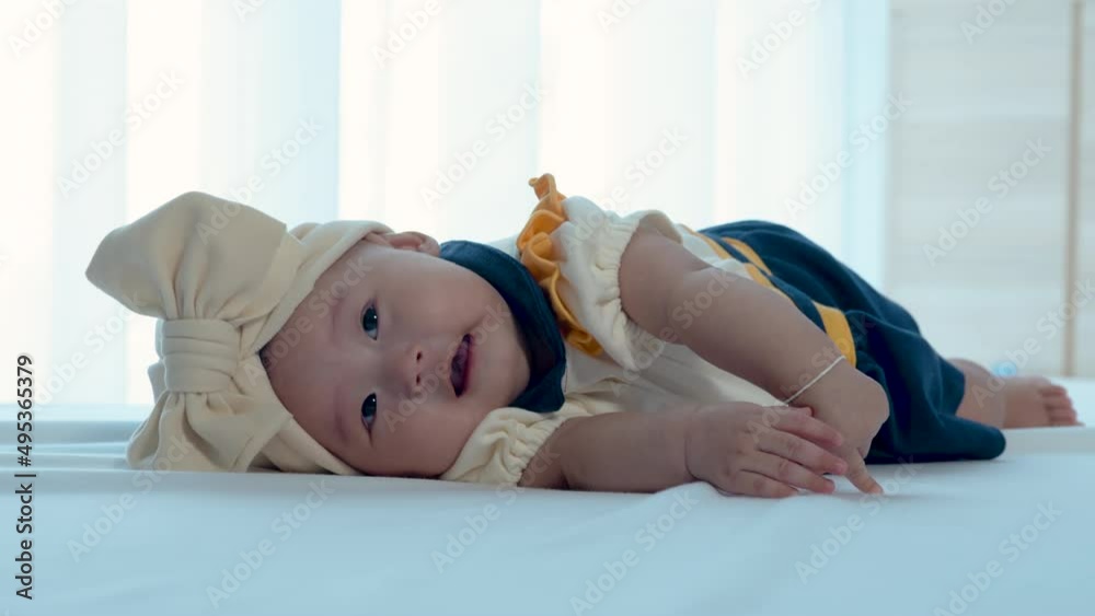 4K 50fps, adolable Asian newborn baby girl, lying on her stomach, flips ...