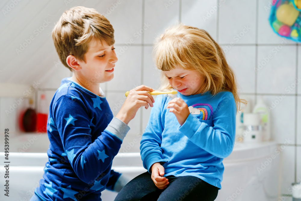 Little preschool girl and preteen school boy brushing teeth. Brother ...