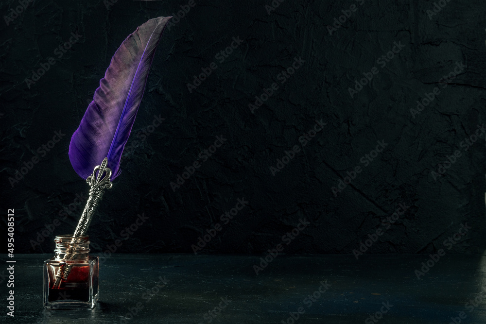 Purple quill pen with a retro ink well, a side view on a dark ...