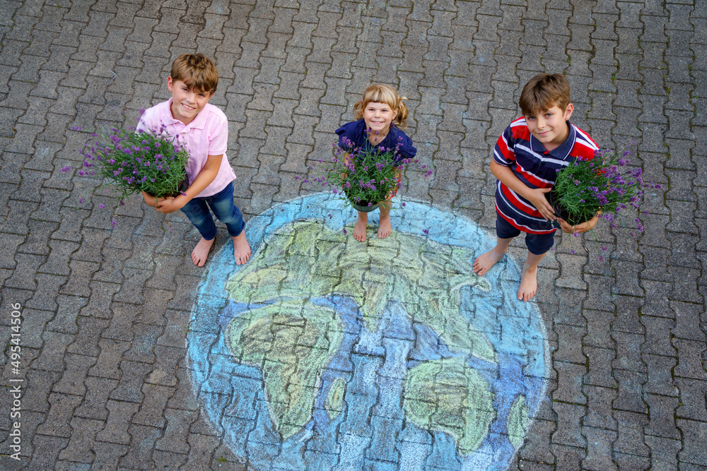 Little preschool girl and two school kids boys with flowers on earth ...