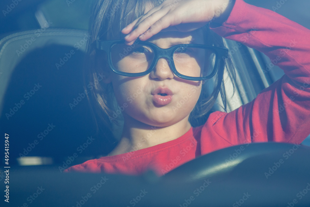 Dangers and risks of underage driving. Young girl drives a car. Stock ...