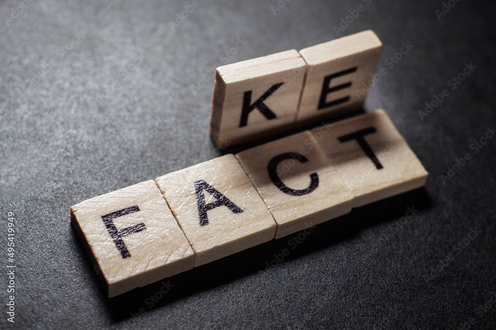 Wooden blocks forming words Fact and Fake on black background. Stock ...