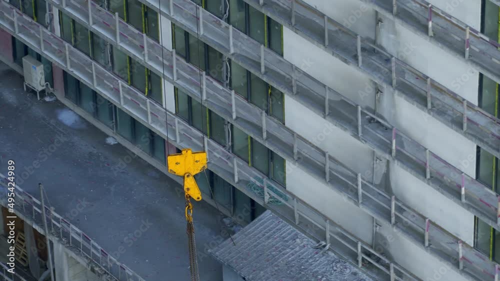 Raise building load to height. Crane lowers loads at construction site ...