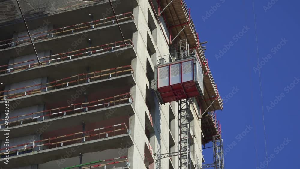 freight elevator at construction site of tall rides up and down. in ...