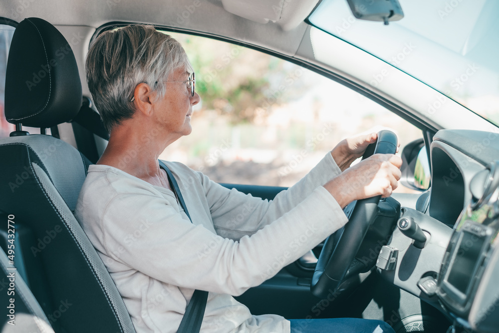 Happy owner. Handsome mature woman sitting relaxed in his newly bought ...