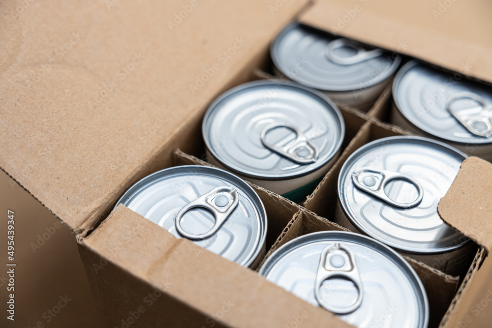 Food cans in an open cardboard box. Concept image for supply chain ...