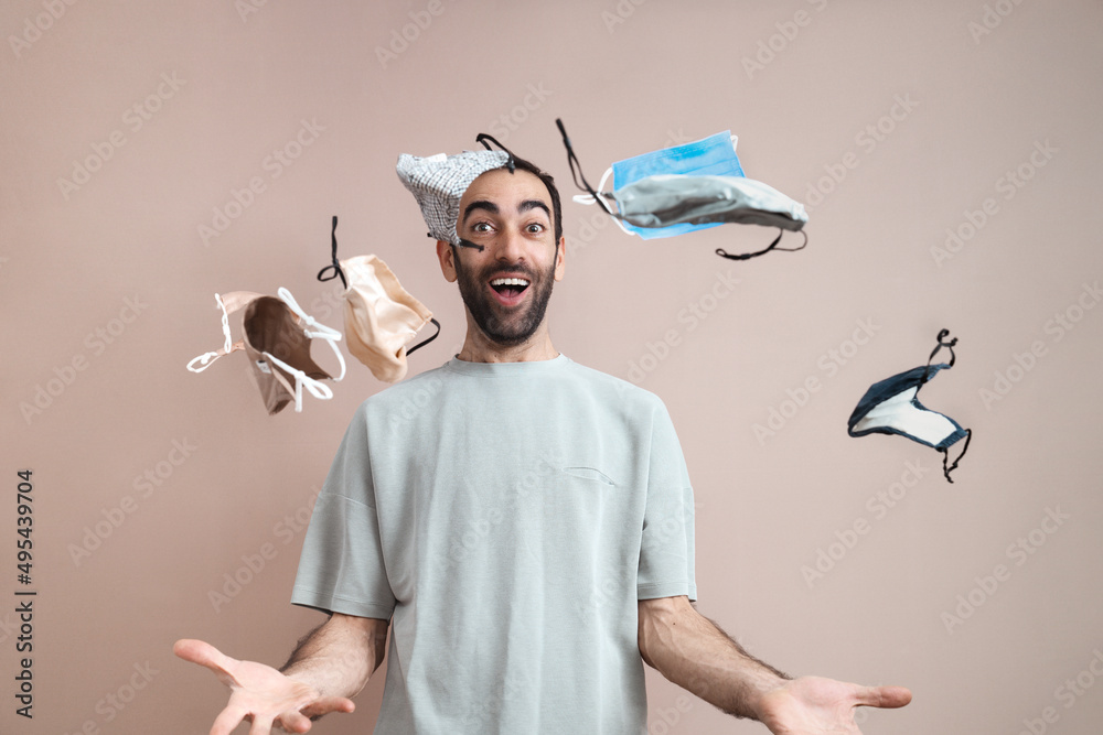 Excited man throwing facemasks against pink background Stock Photo ...