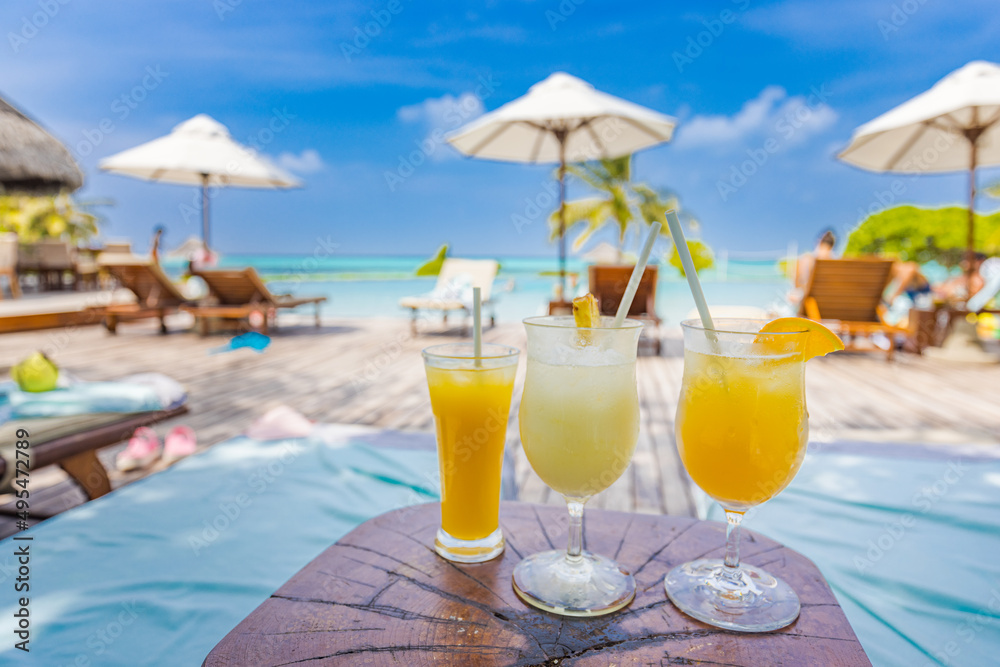 Colorful cocktails on luxury beach resort. Blurred poolside, chairs ...