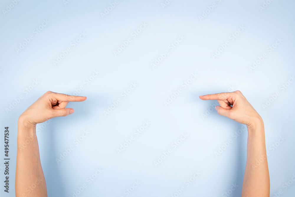 Woman hands pointing index finger to each other towards the center ...