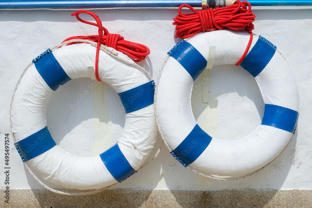 two rubber rings and red rope hanging on the wall used for swimming to ...