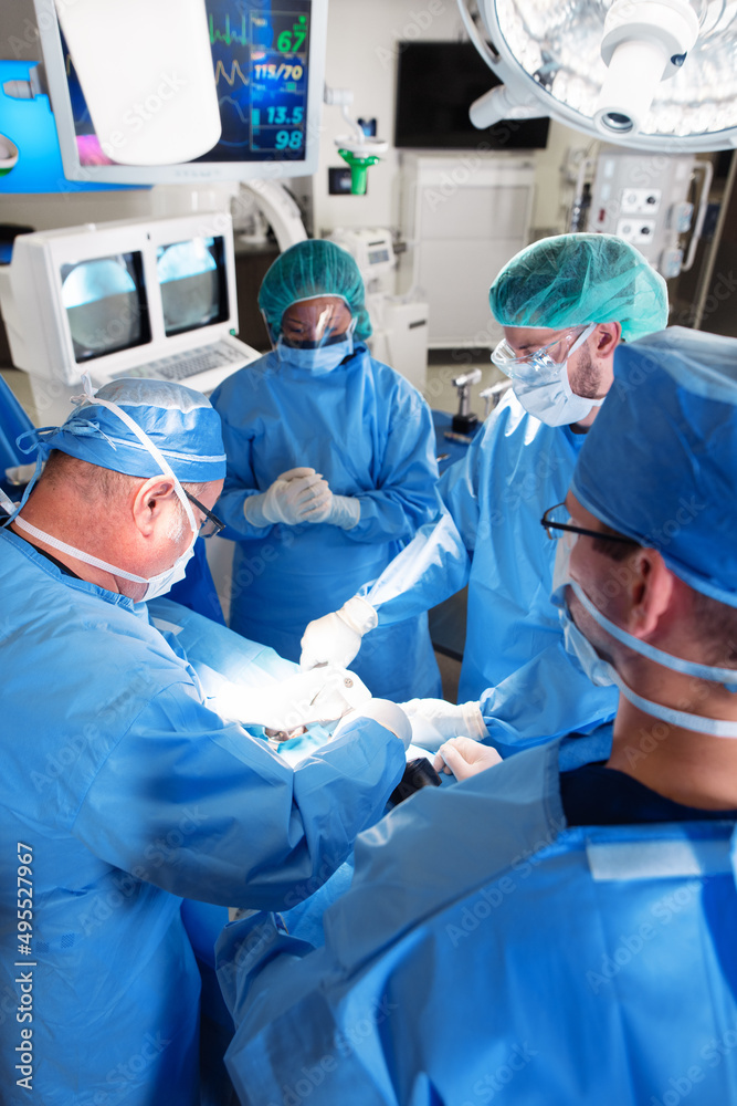Medical team wearing scrubs operating on anaesthetized patient Stock ...
