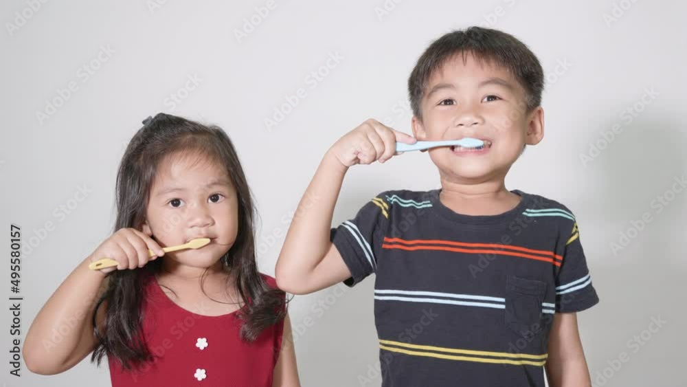 Little cute kid boy and girl 3-6 years old brushing teeth and smile in ...