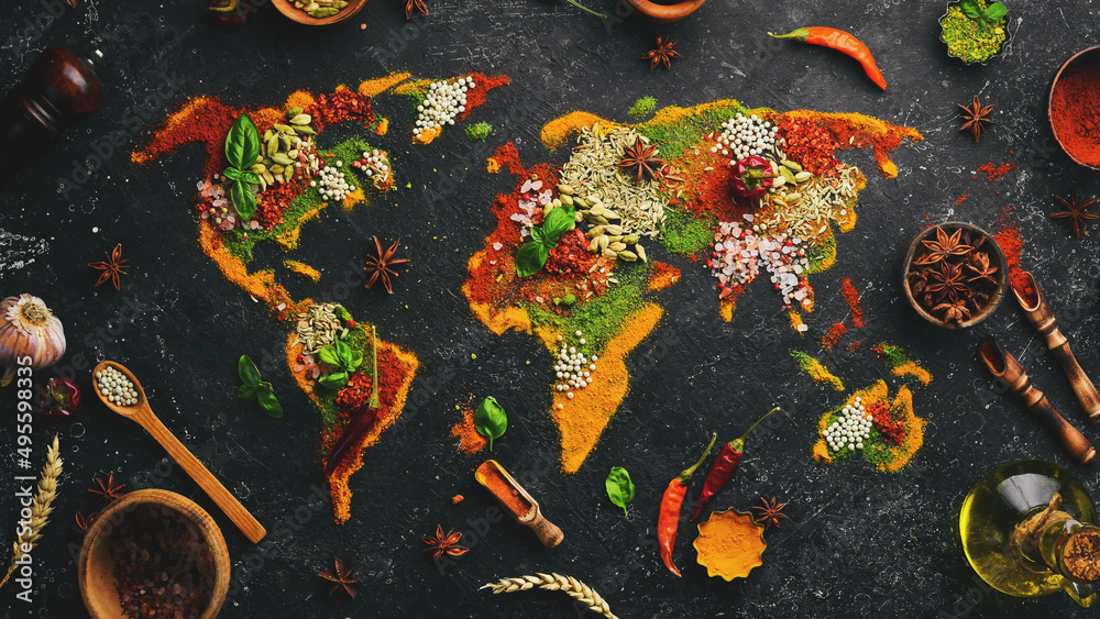 Spices and herbs around the world in the shape of a world map on a dark ...