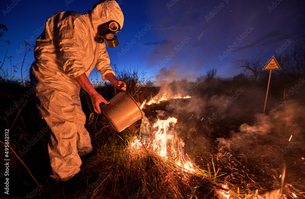 Research scientist fighting fire in field with blue night sky on ...
