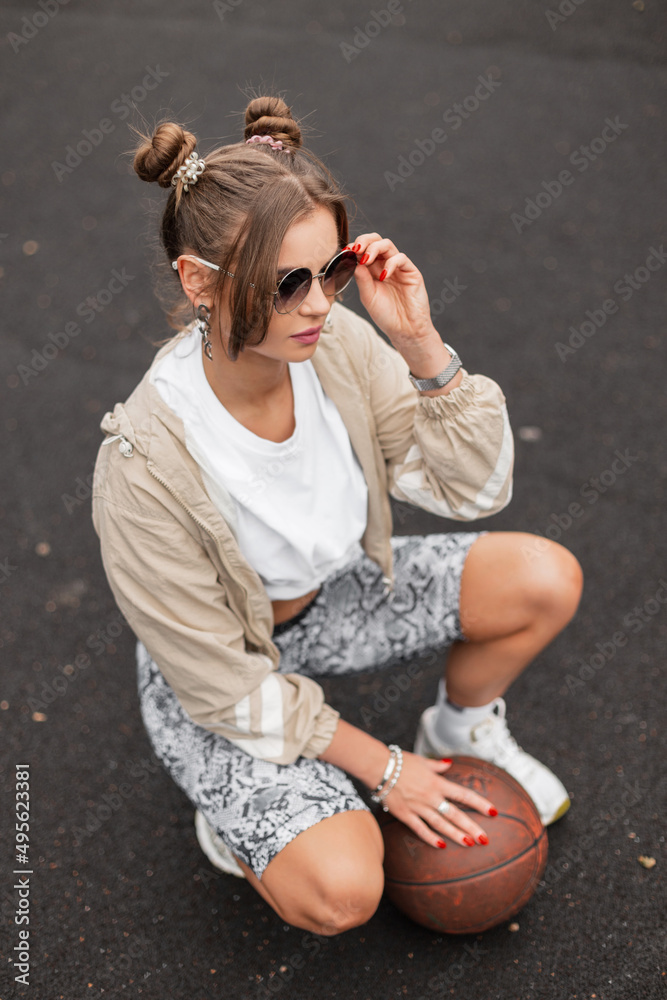 Stylish beautiful young girl in fashionable sports clothes with a ...