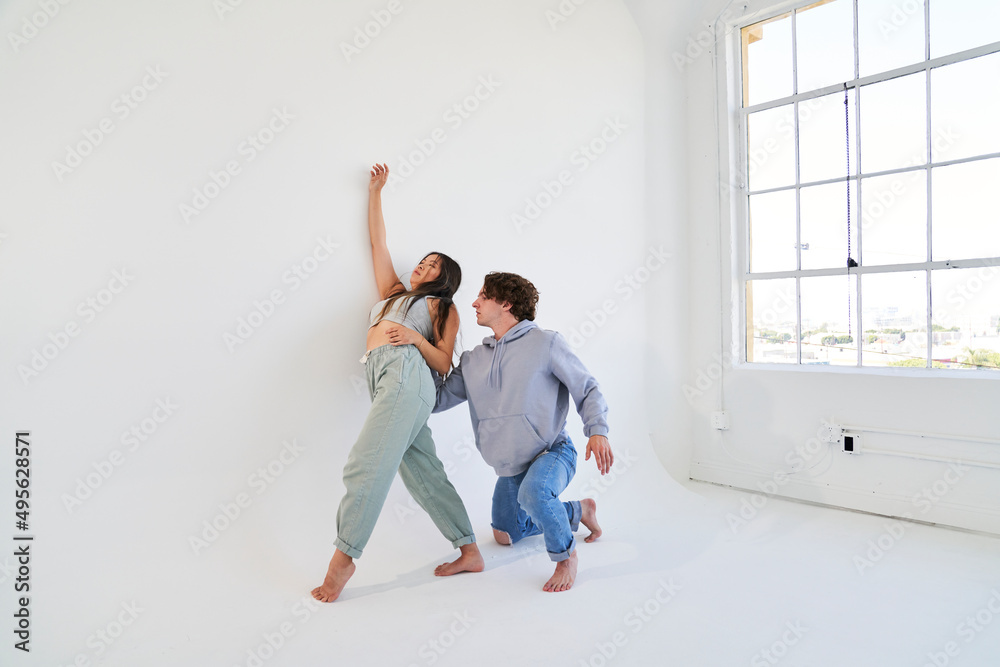 man kneeling with dancing woman by window Stock Photo | Adobe Stock
