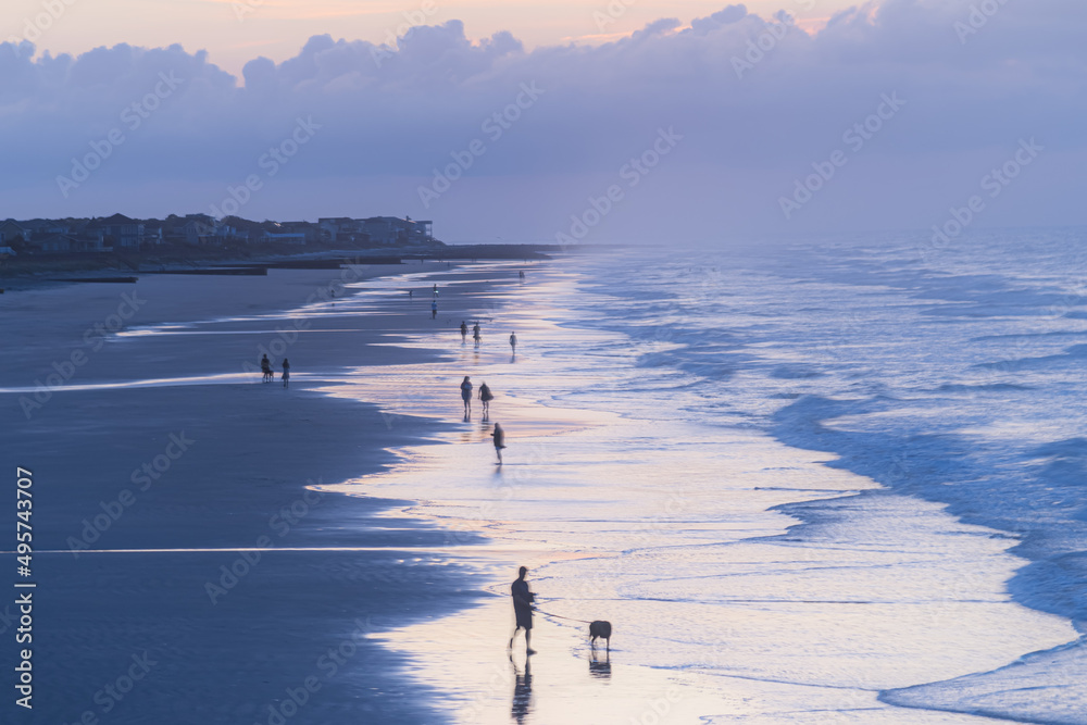 Beautiful scenery of people on the beach with splashing waves under the ...