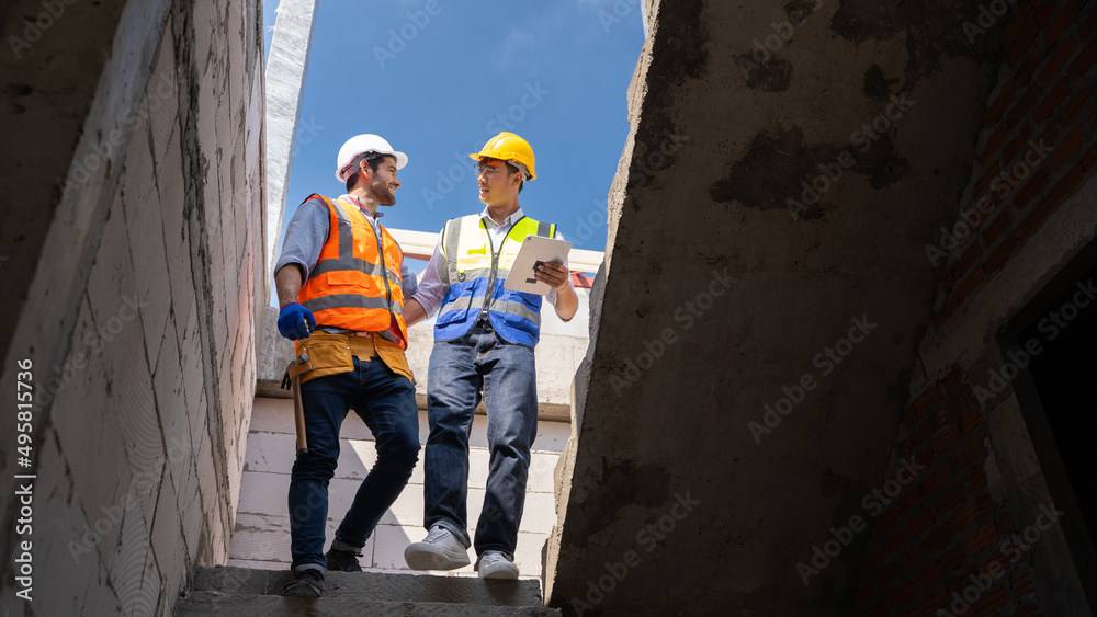 Civil Engineer Two handsome workers walk together at a construction ...