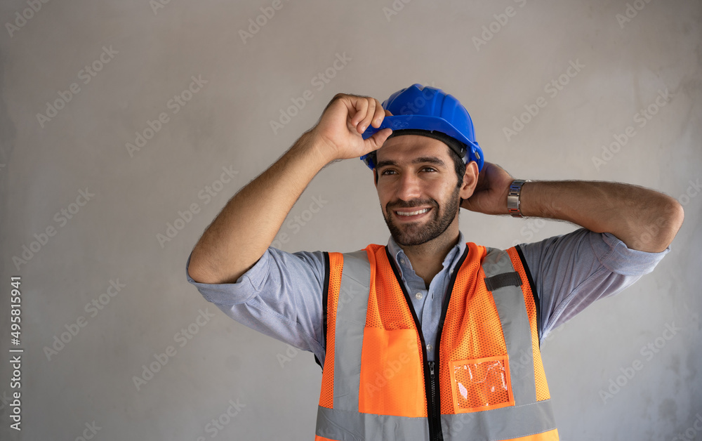 An engineer of Middle Eastern descent smiling,handsome, holding a hard ...