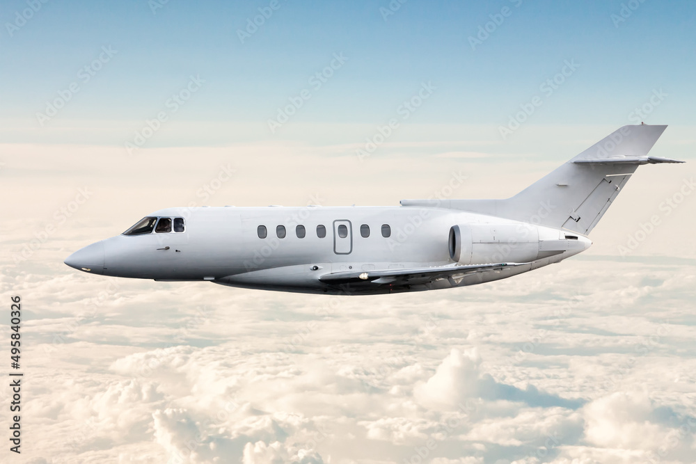 White modern luxury private jet flies in the air above the clouds Stock ...