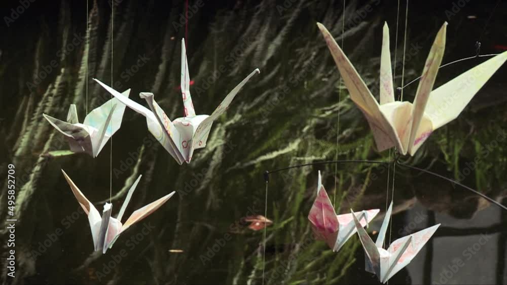 Six Orizurus - Paper birds fly over the water of a lake. “Orizuru” is ...