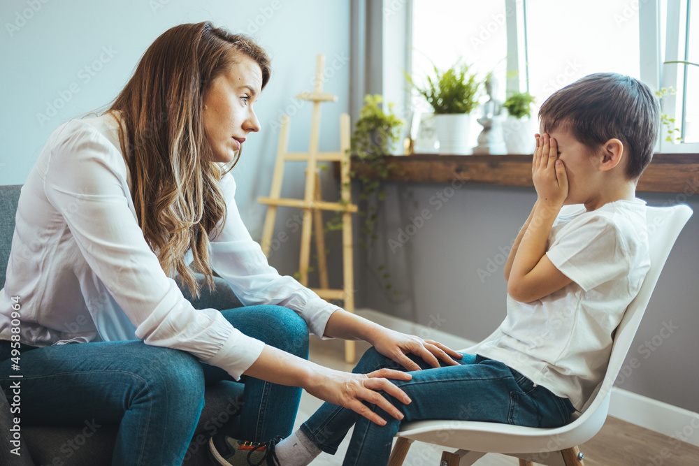 Counseling psychologist. Little boy in white t-shirt is worried and ...