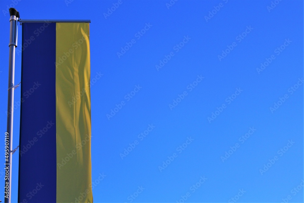 Flag of Ukraine as a banner flying vertically against a clear blue sky ...